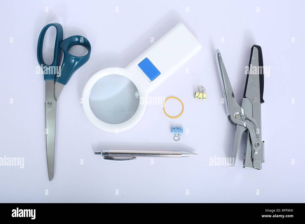 Photo of ball pen, stapler, scissor, paper clip and magnifying glass ...