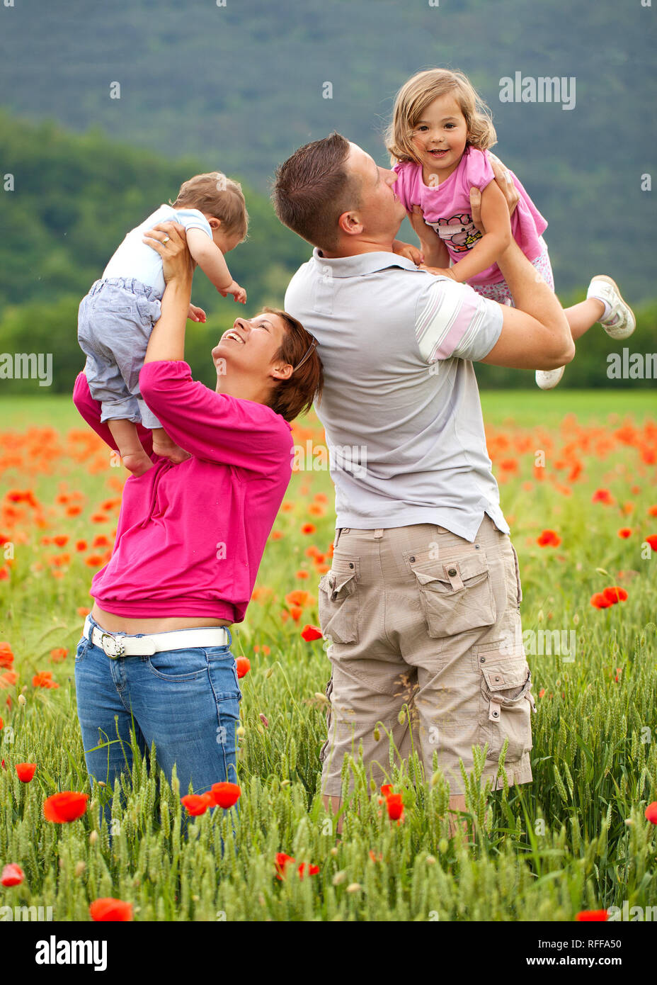 Family in poppy field having fun Stock Photo - Alamy