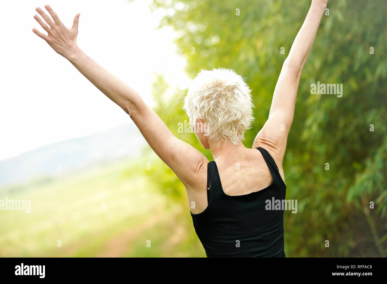 Woman runner with hand raised high Stock Photo - Alamy