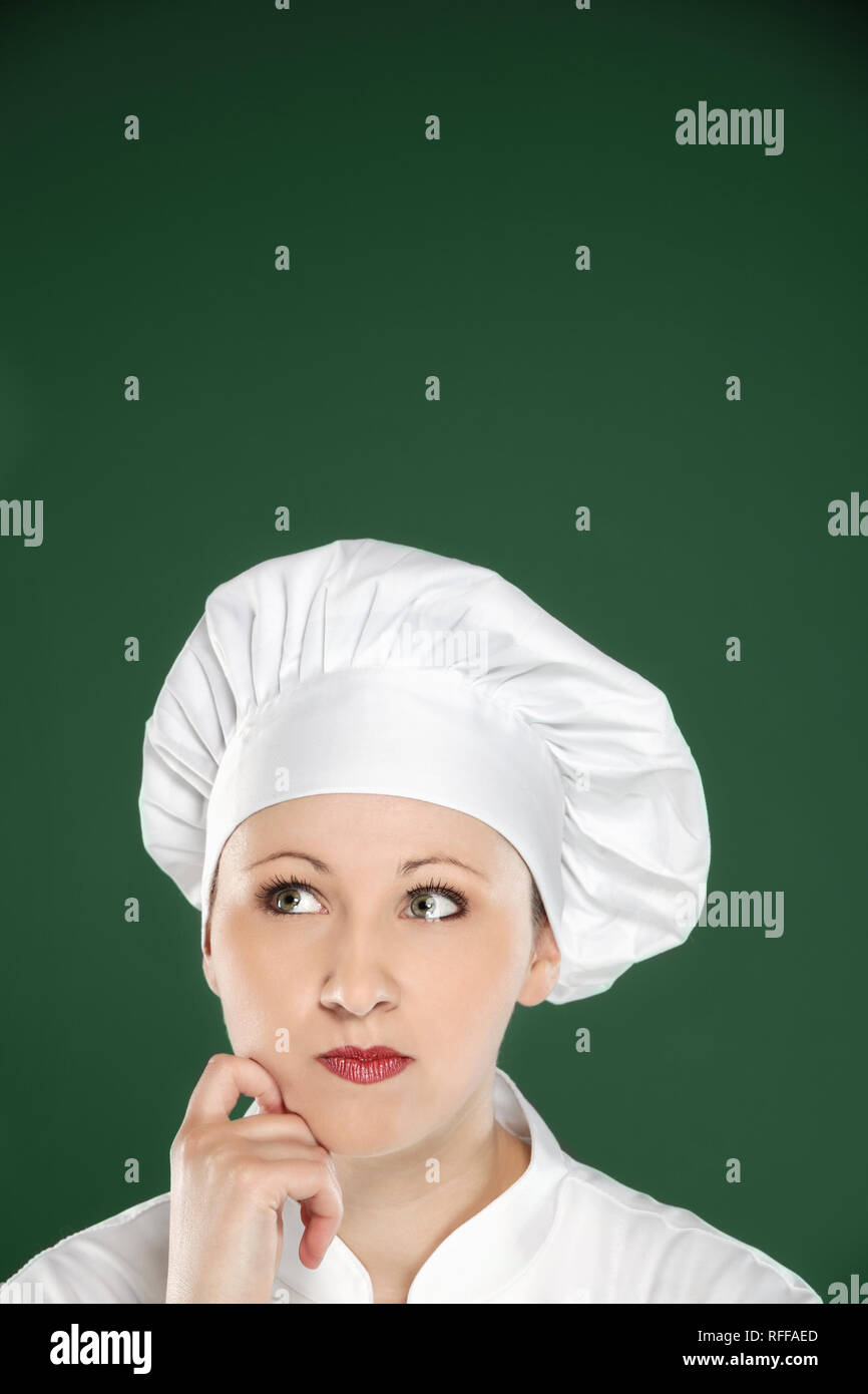 Young female chef thinking against green background Stock Photo - Alamy