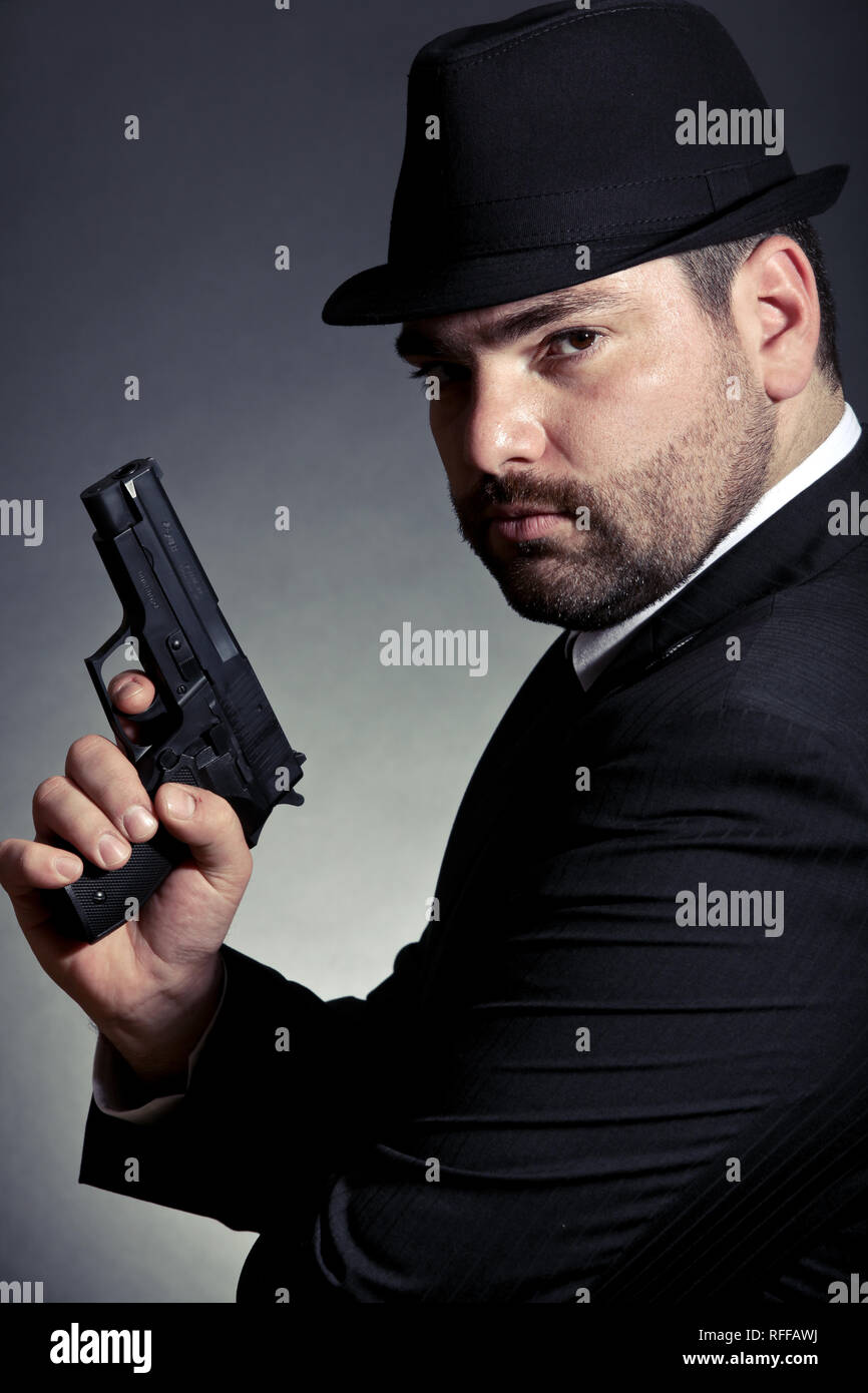Dangerous man in suit with a gun Stock Photo - Alamy