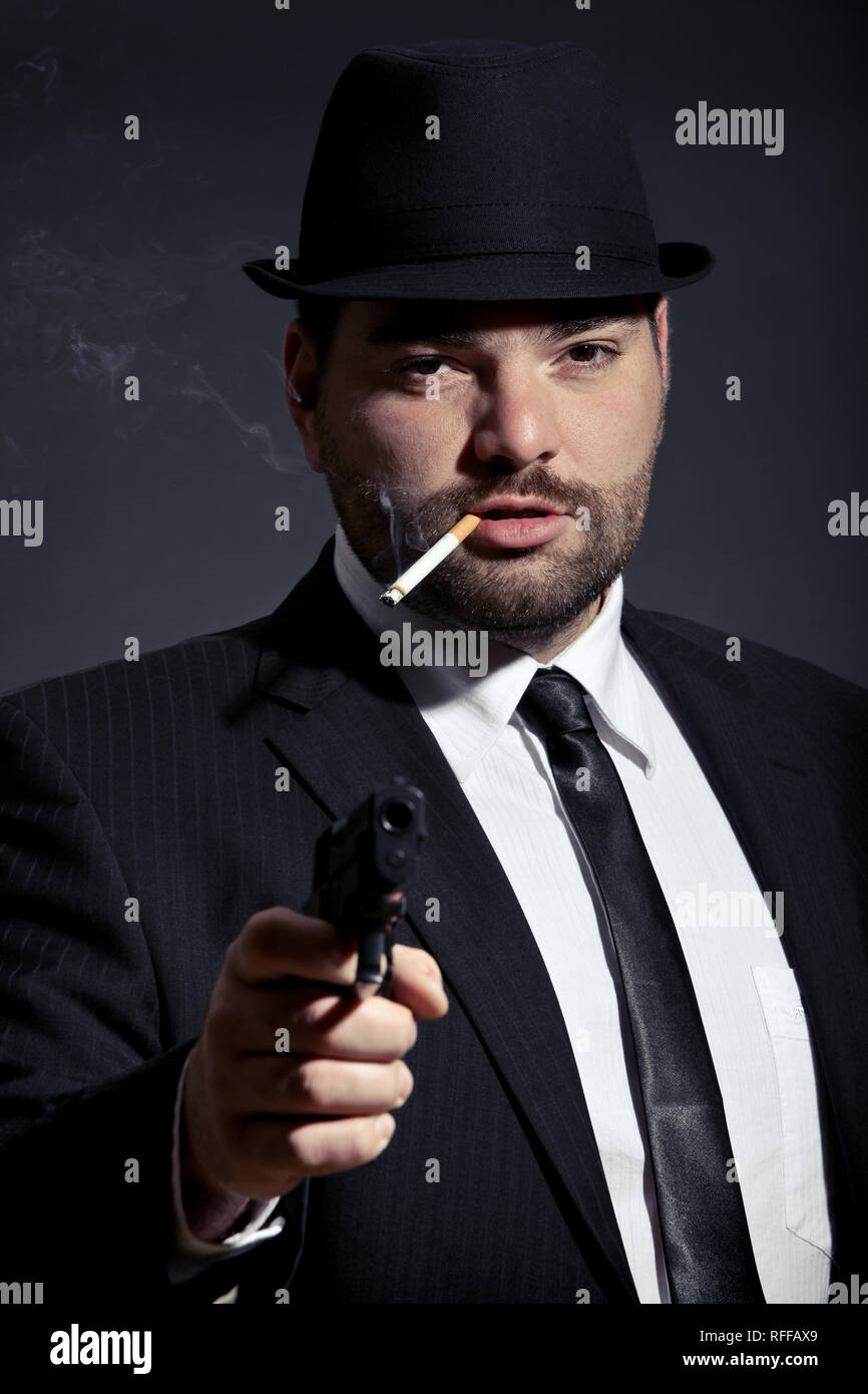 Dangerous man in suit with a gun Stock Photo - Alamy