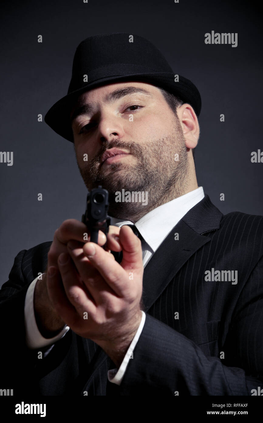 Dangerous man in suit with a gun Stock Photo - Alamy