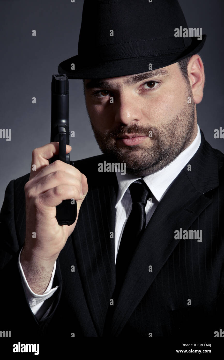 Dangerous man in suit with a gun Stock Photo - Alamy