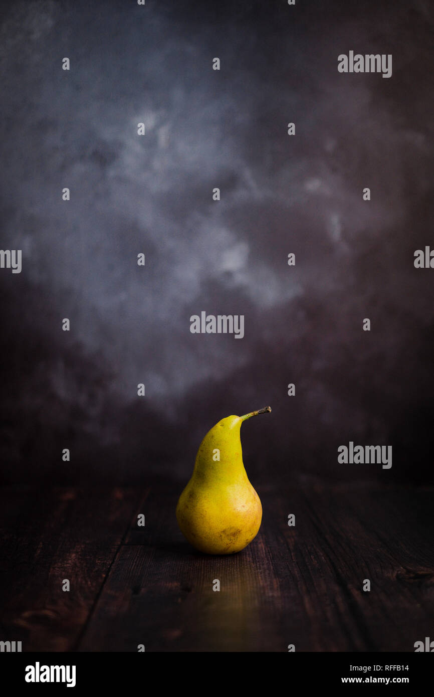 A single pear against a dark background Stock Photo - Alamy