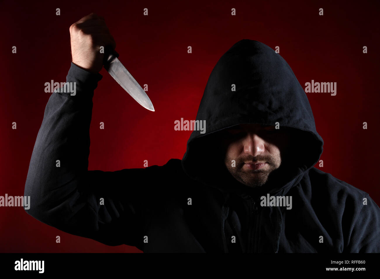 Dangerous man with knife against red background Stock Photo - Alamy