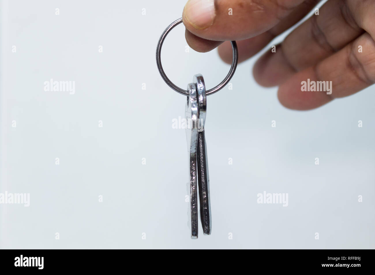 Male hand holding keyring isolated on white background with copy space ...