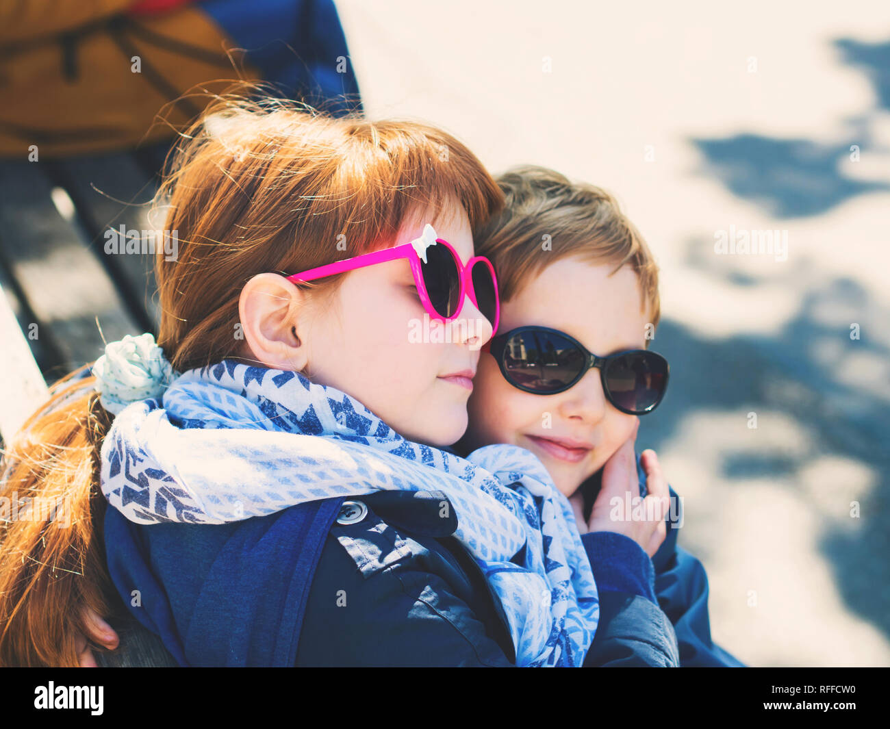 Two cute kids, siblings hugging outdoors with jackets and scarves Stock ...