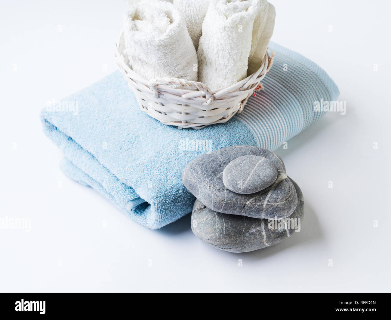 Fresh folded towels and stones on white background. Spa, bathroom ...