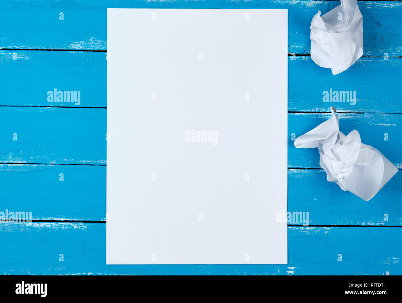 blank white rectangular sheet of paper and crumpled pieces of paper on ...