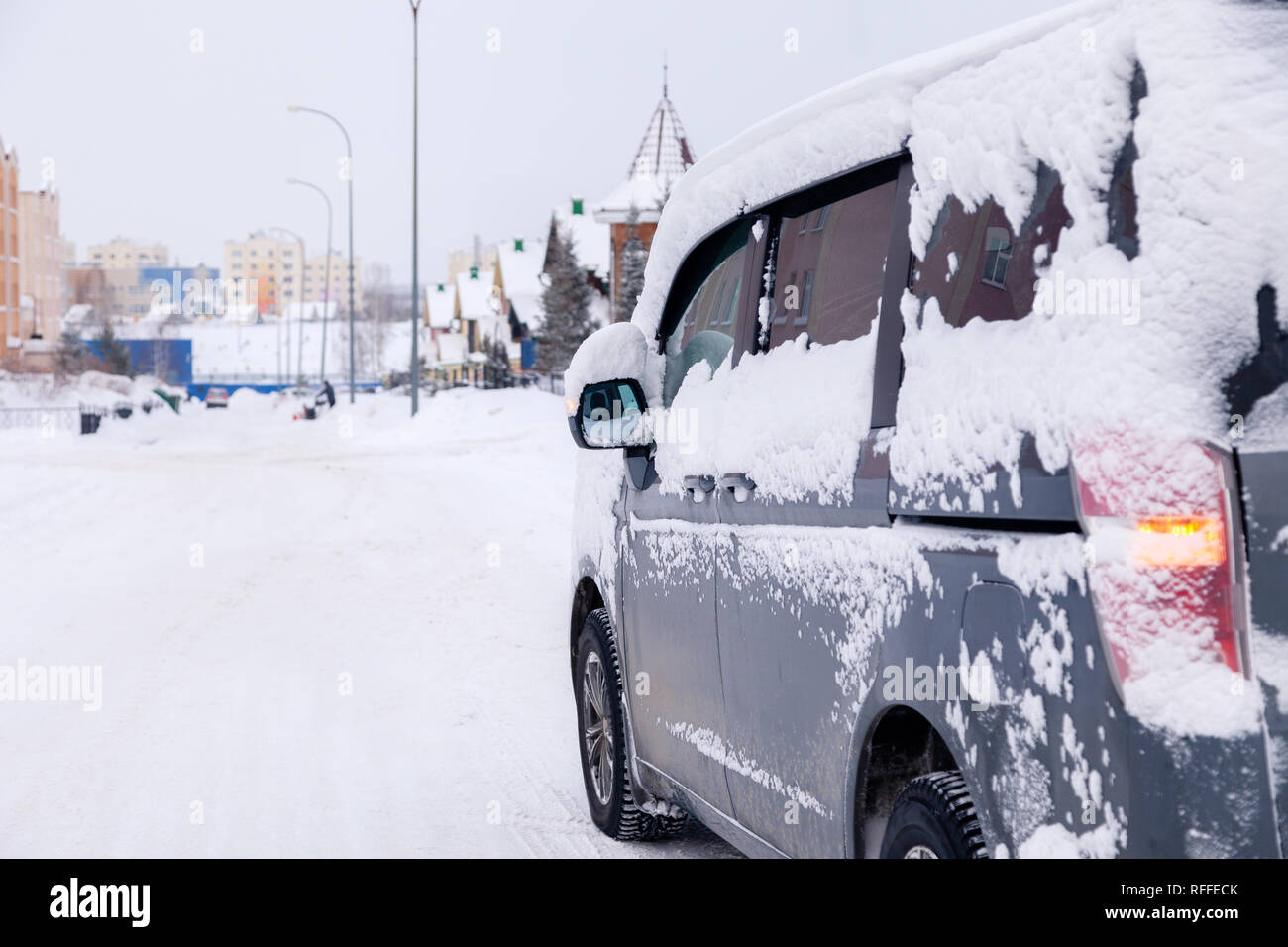 Closeup gray minibus dirty car covered with snow on city background ...