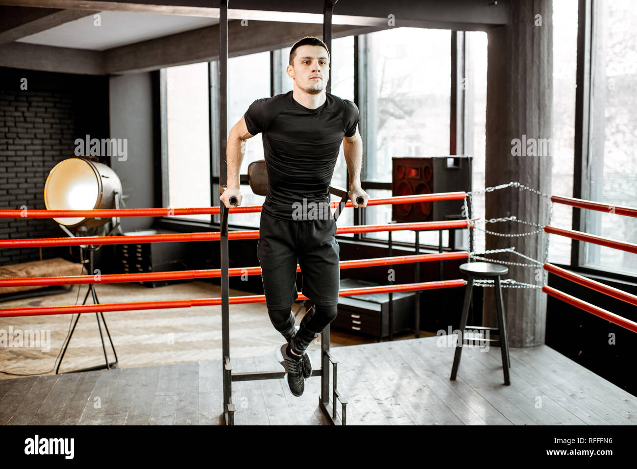 Young athletic man pulling up on the bar, warming up before the ...