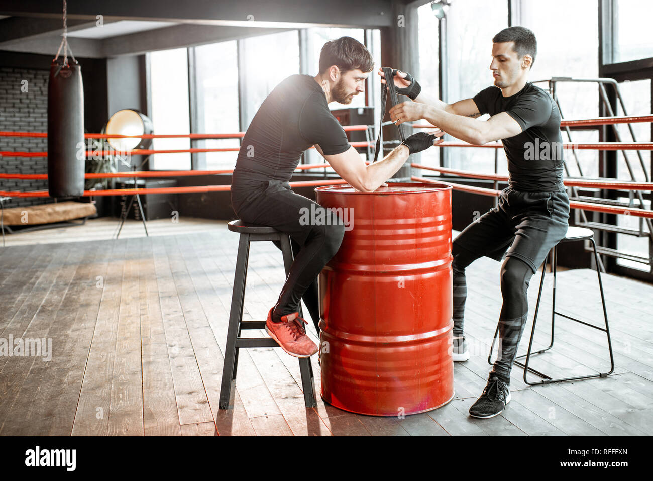 Trainer winding bandage on the wrist for a man, sitting at the red ...