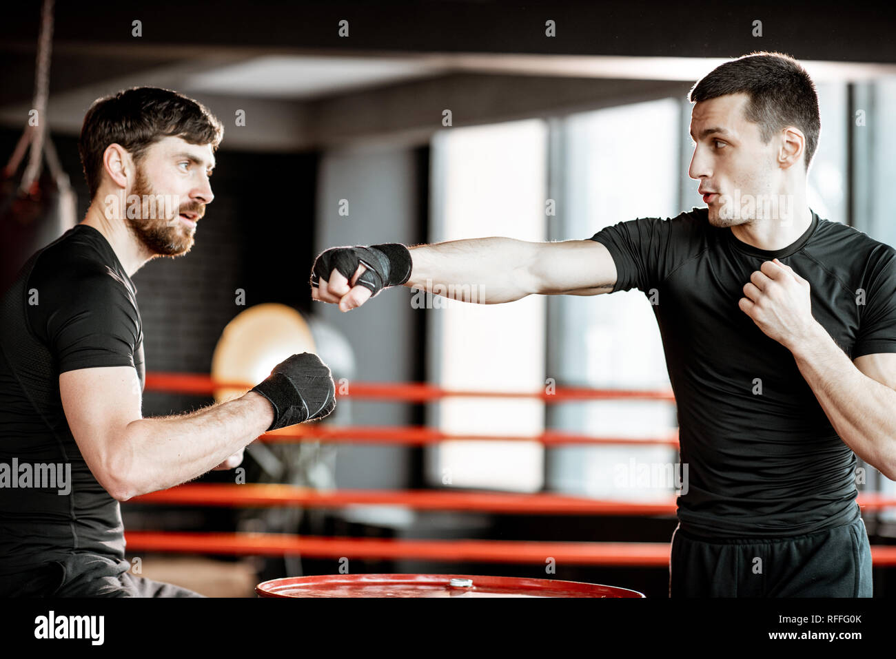 Boxing trainer showing to a man how to fight, teaching to box in the ...