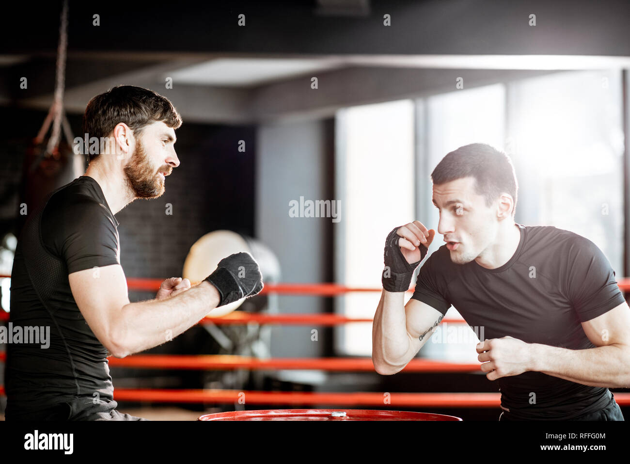 Boxing trainer showing to a man how to fight, teaching to box in the ...