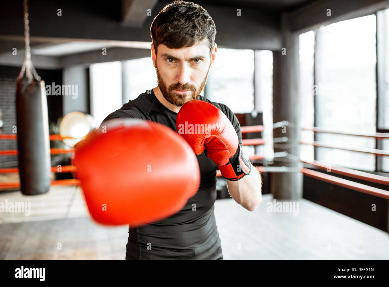 Portrait of an athletic man as a boxer in red boxing gloves on the ...