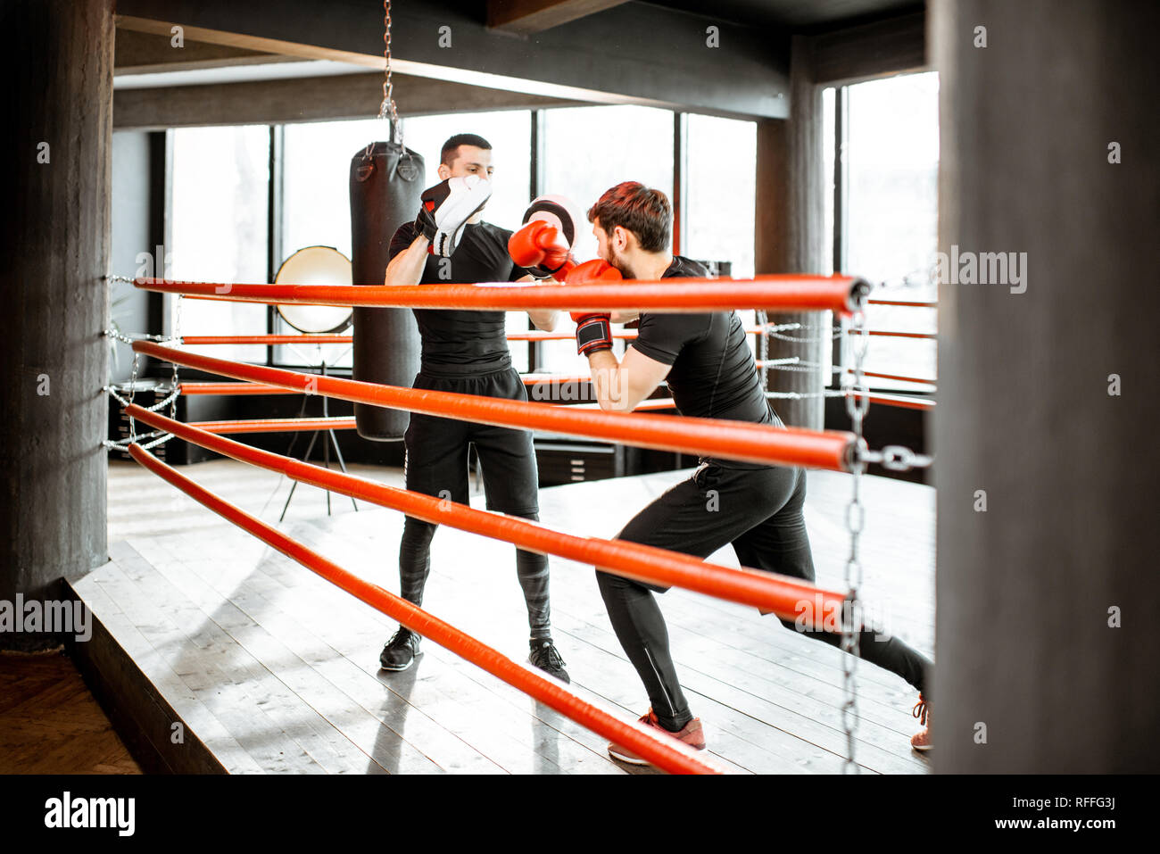 Athletic man fighting during the training with boxing trainer on the ...