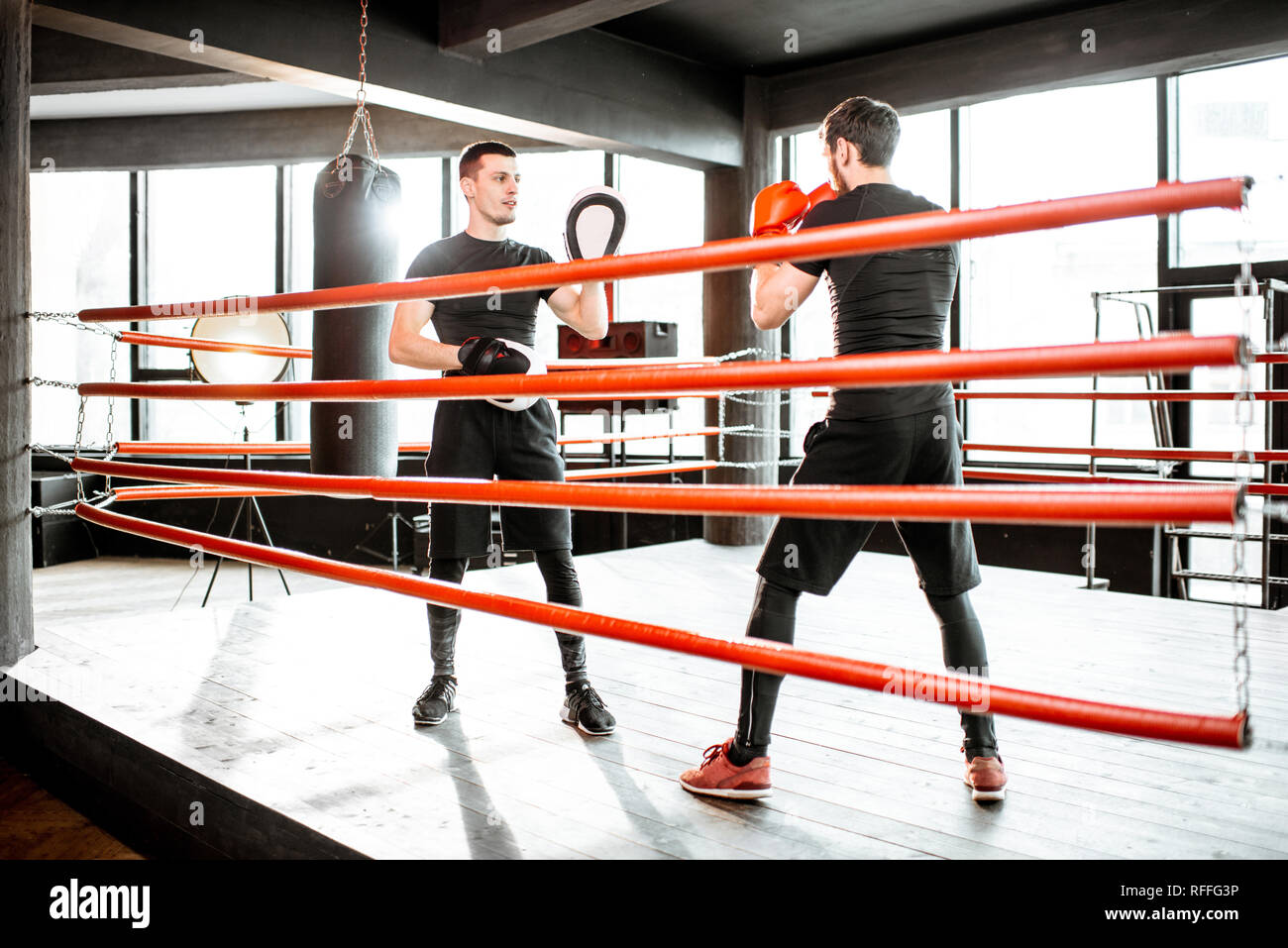 Athletic man fighting during the training with boxing trainer on the ...