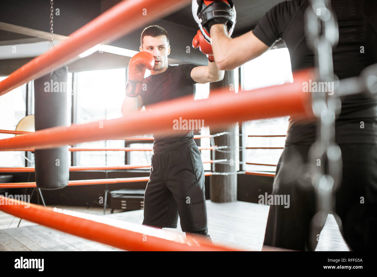 Athletic man fighting during the training with boxing trainer on the ...