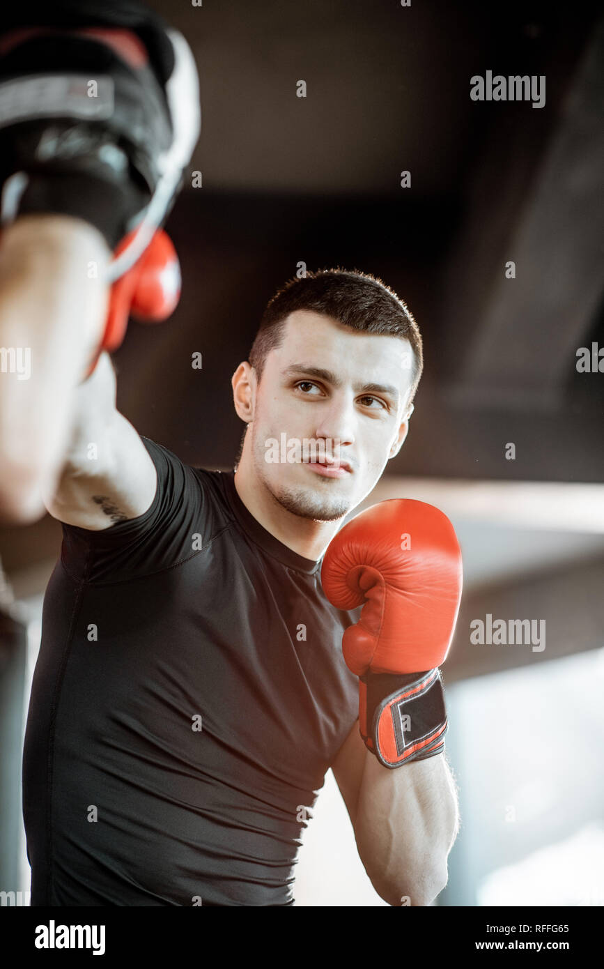 Athletic man fighting during the training with boxing trainer on the ...