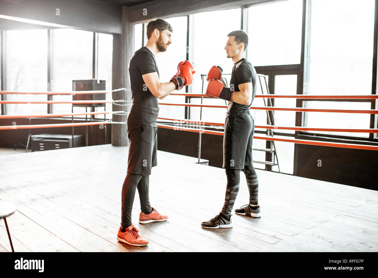 Two professional boxers in black sportswear red gloves standing ...