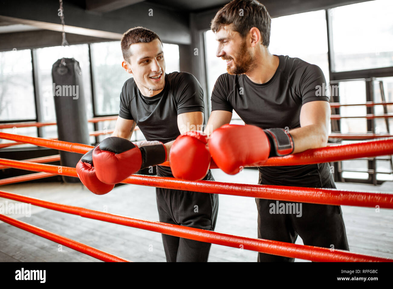 Two athletic men in black sportswear talking together, having fun ...