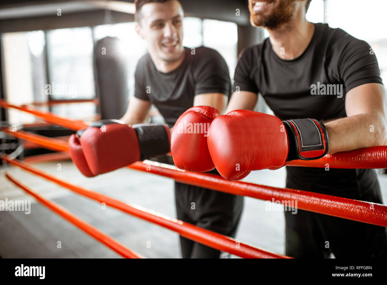 Two athletic men in black sportswear talking together, having fun ...
