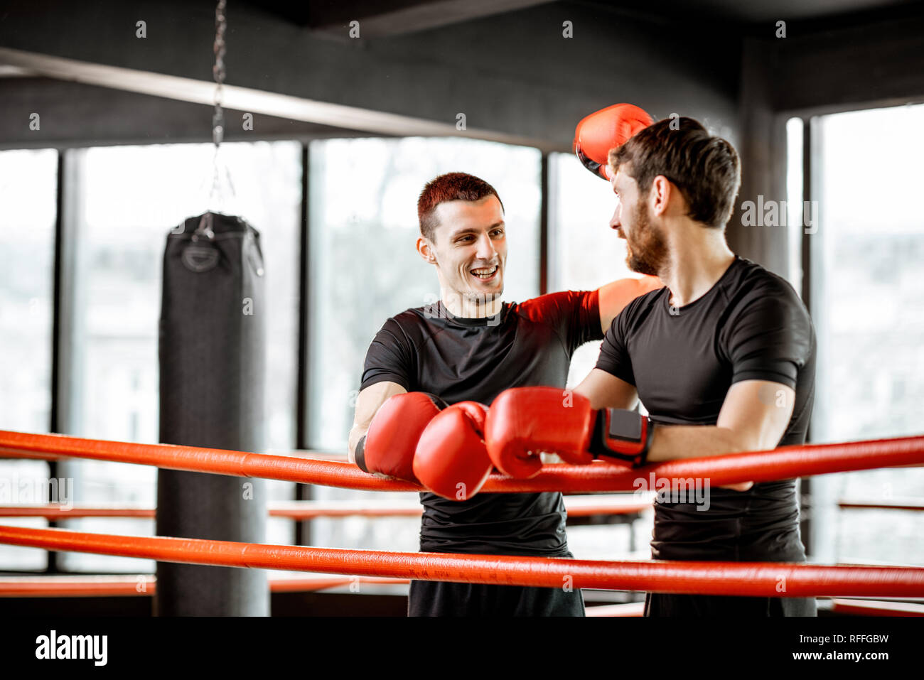 Two athletic men in black sportswear talking together, having fun ...