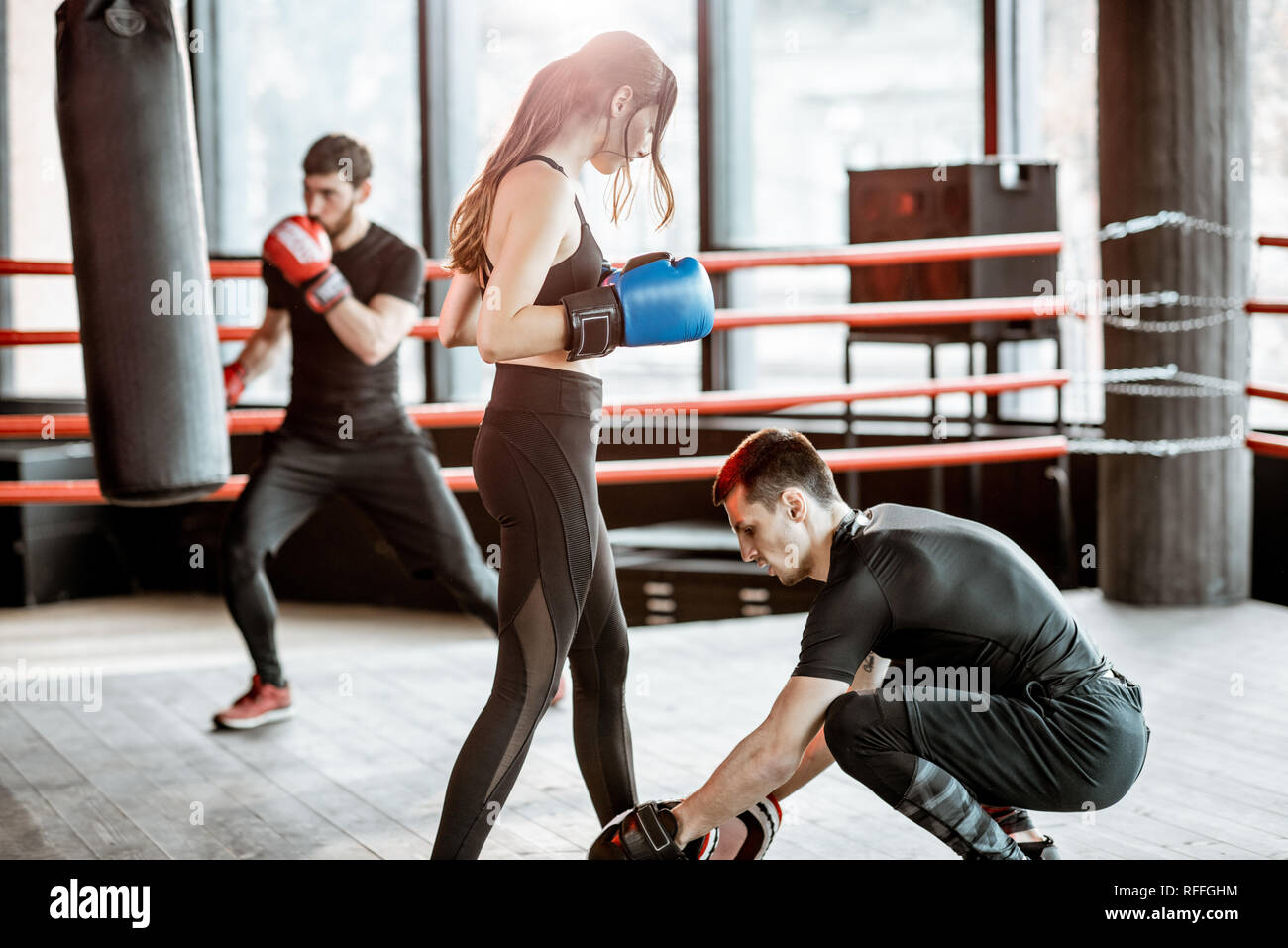 Young woman training to box with personal coach on the boxing ring at ...
