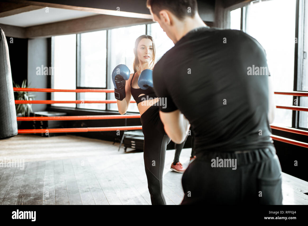 Young woman training to box with personal coach on the boxing ring at ...