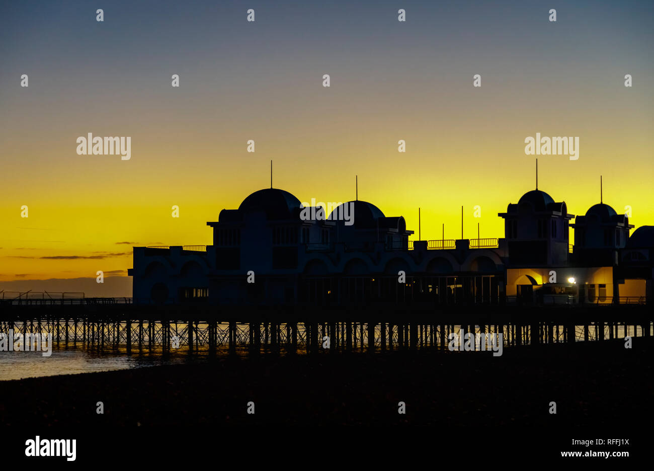 Victorian structure, South Parade Pier in silhouette and the beach ...
