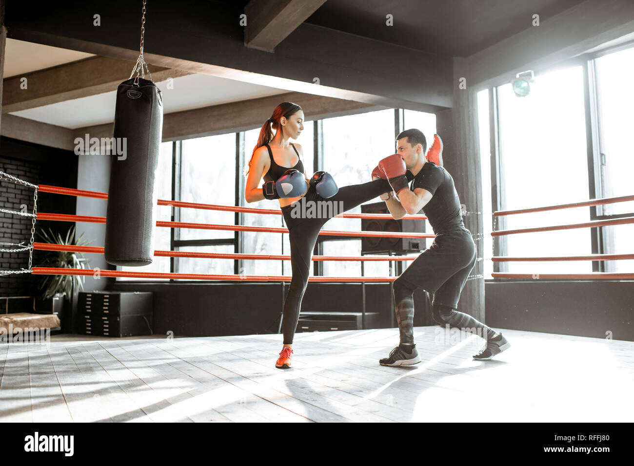 Young woman training to box with personal coach on the boxing ring at ...