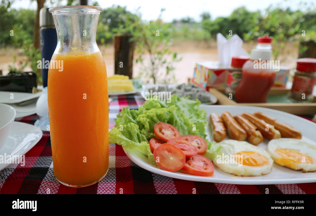 A carafe of homemade fresh squeezed tangerine orange juice served with ...