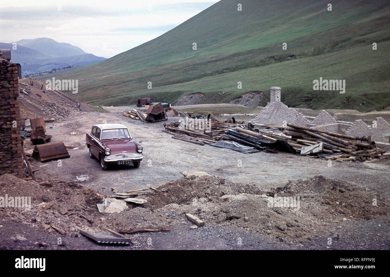 1960s, historical, 2-door Ford Anglia car parked on gravel at the ...