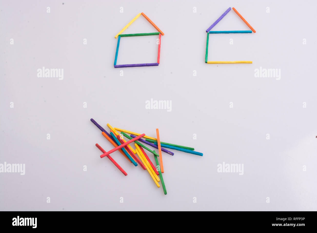 Two houses made of colorful sticks and a bunch of sticks aside. One not ...