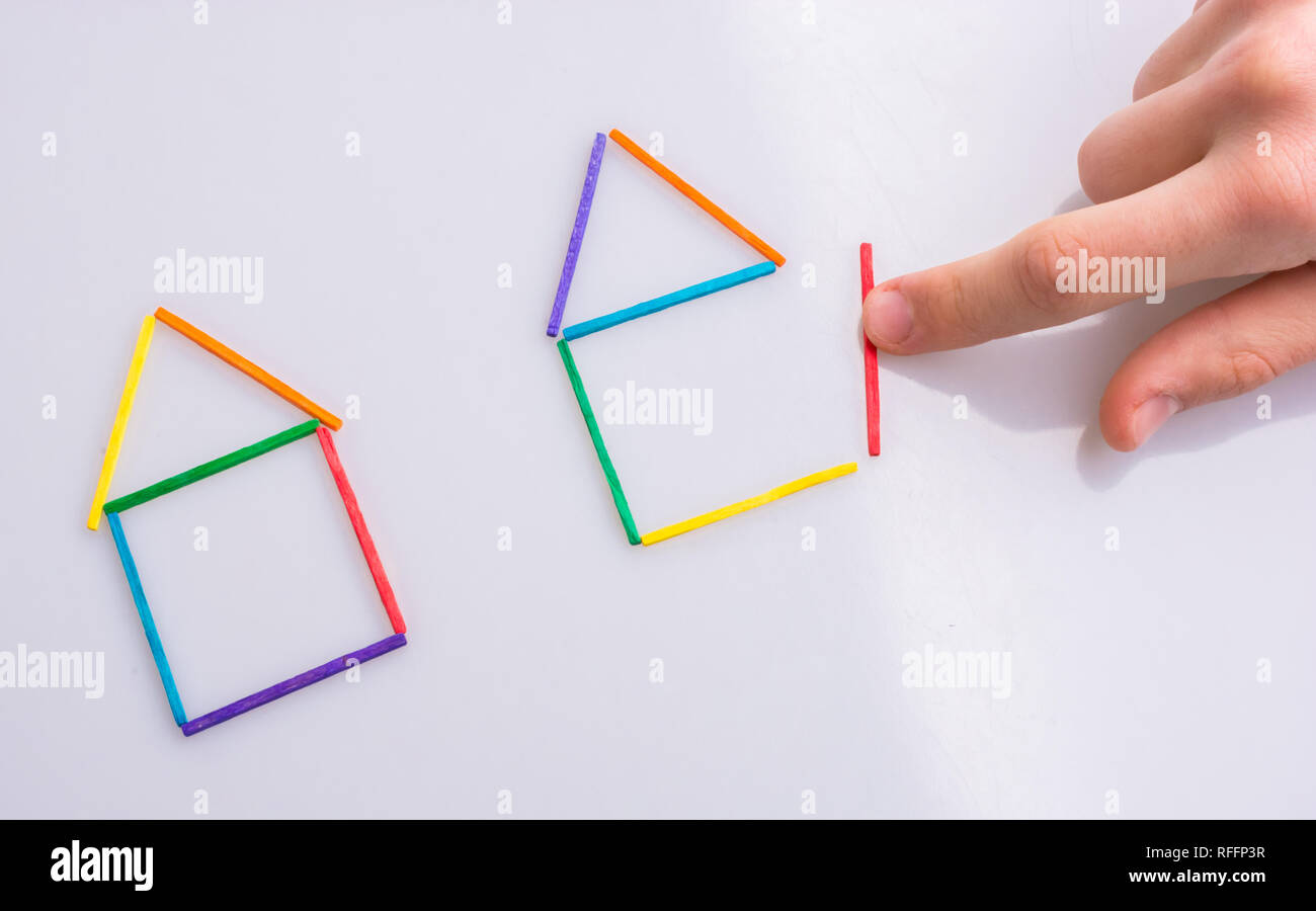 Hand building two houses made of colorful sticks Stock Photo - Alamy