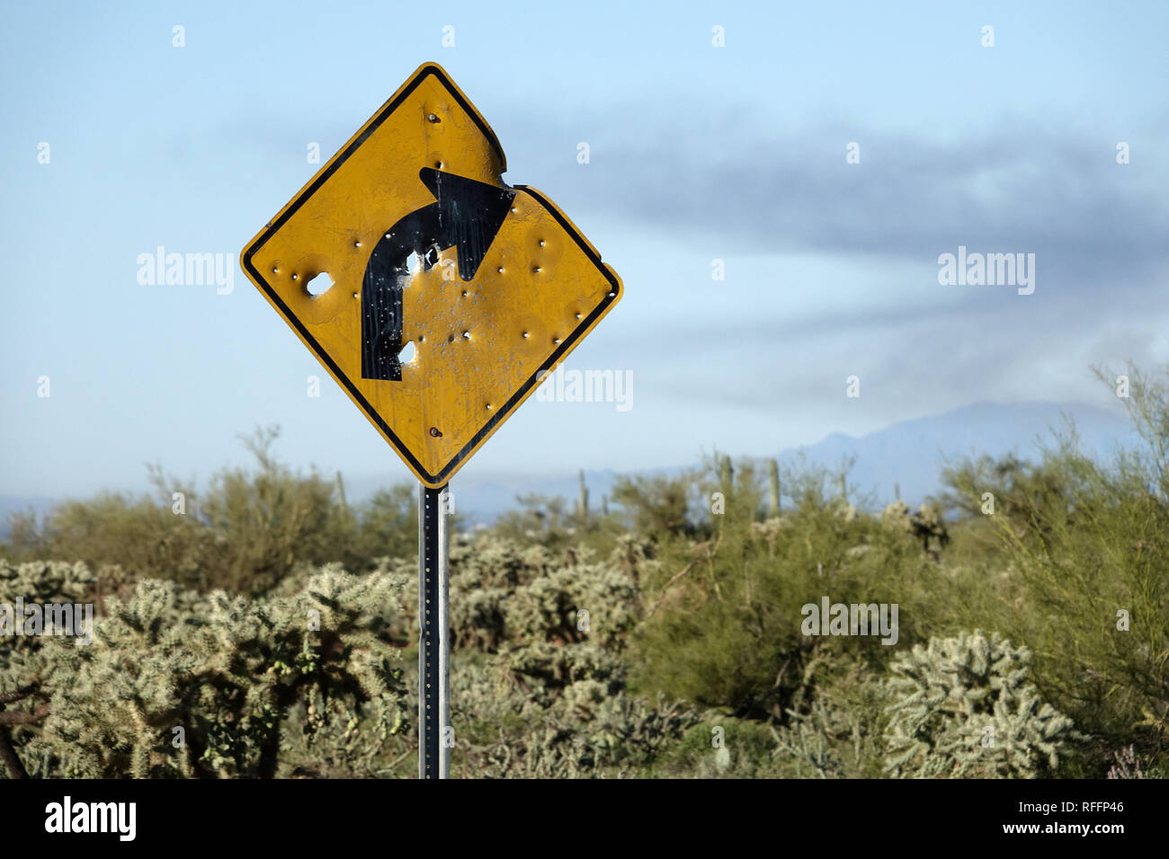 A sign signaling a curve on a dirt road in the Phoenix desert is ...
