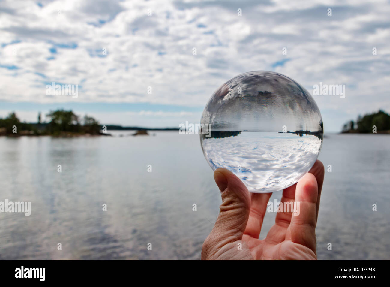 hand holding acrylic crystal ball by a lake Stock Photo - Alamy