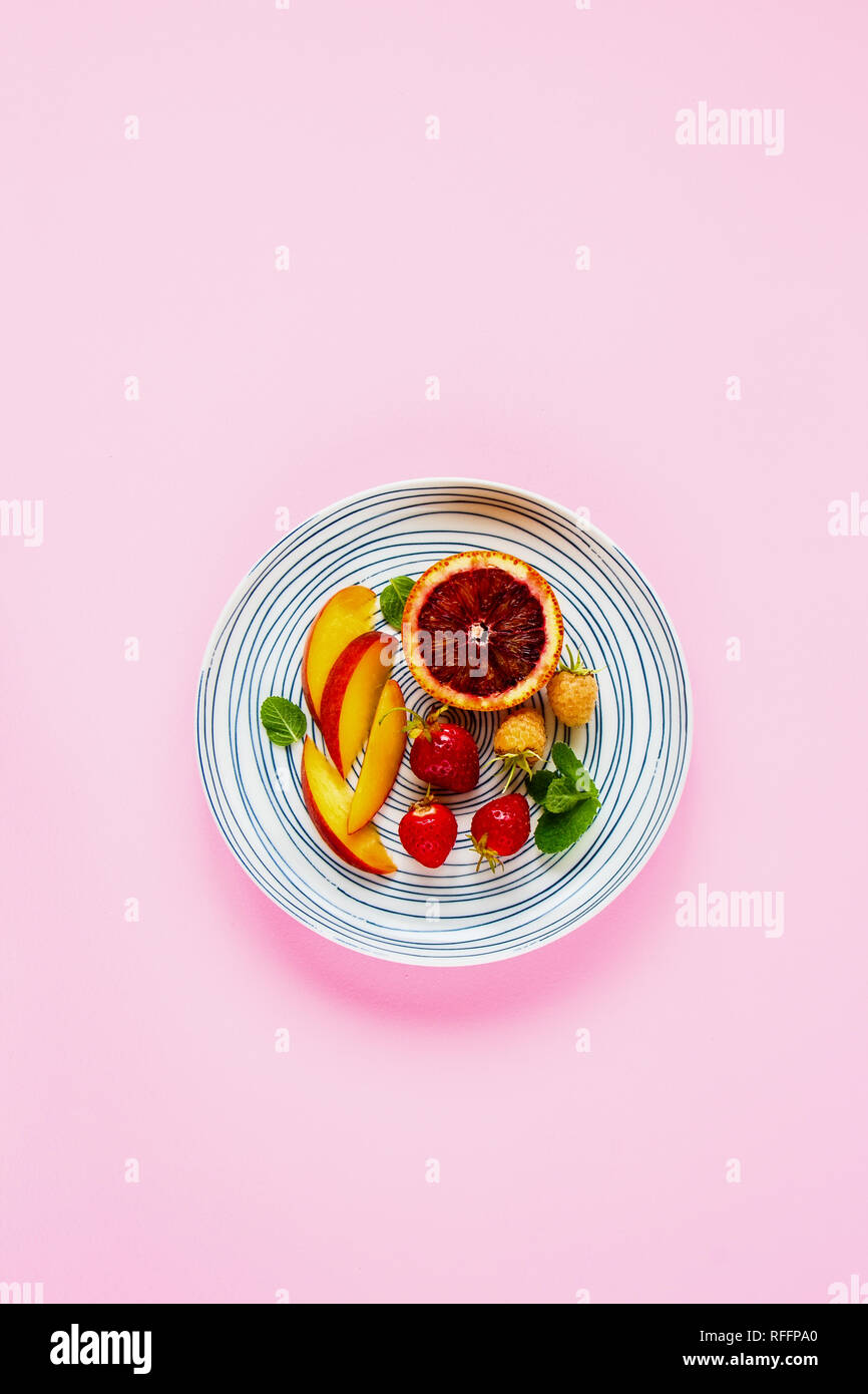 Flat lay of fruits and berries on pastel pink background. Food concept ...