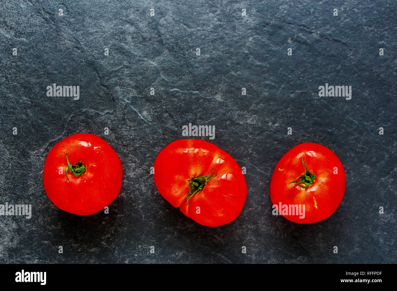 Three tomato on dark copy space background flat lay, top view Stock ...