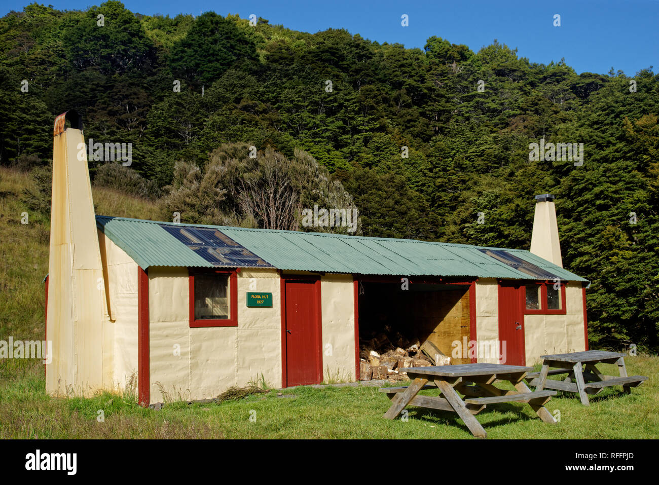 Flora hut, DoC hut or Dept of Conservation hut, with picnic tables ...
