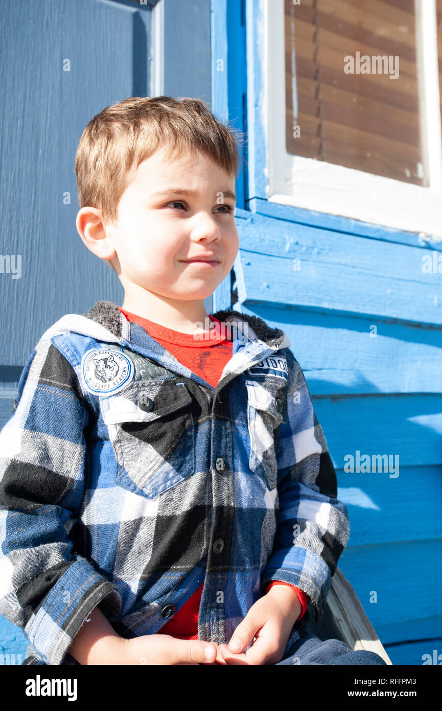 Boy in front of a blue house Stock Photo - Alamy