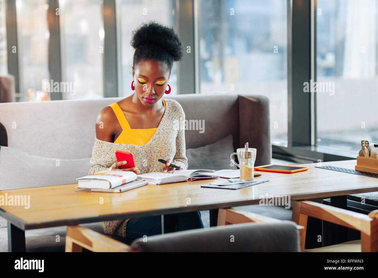 African-American student making some notes while studying Stock Photo ...