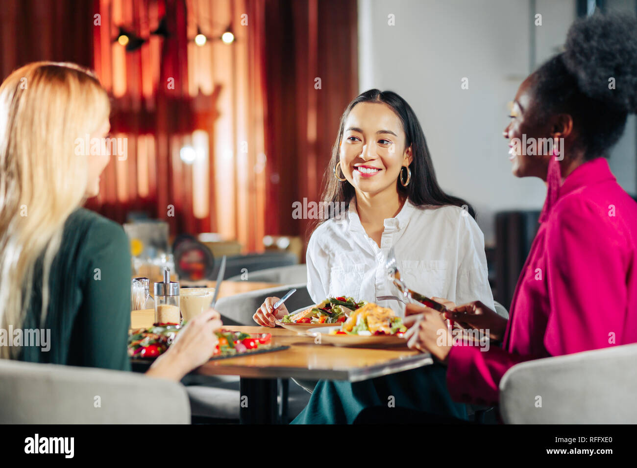 Three friends meeting on restaurant for tasty lunch together Stock ...