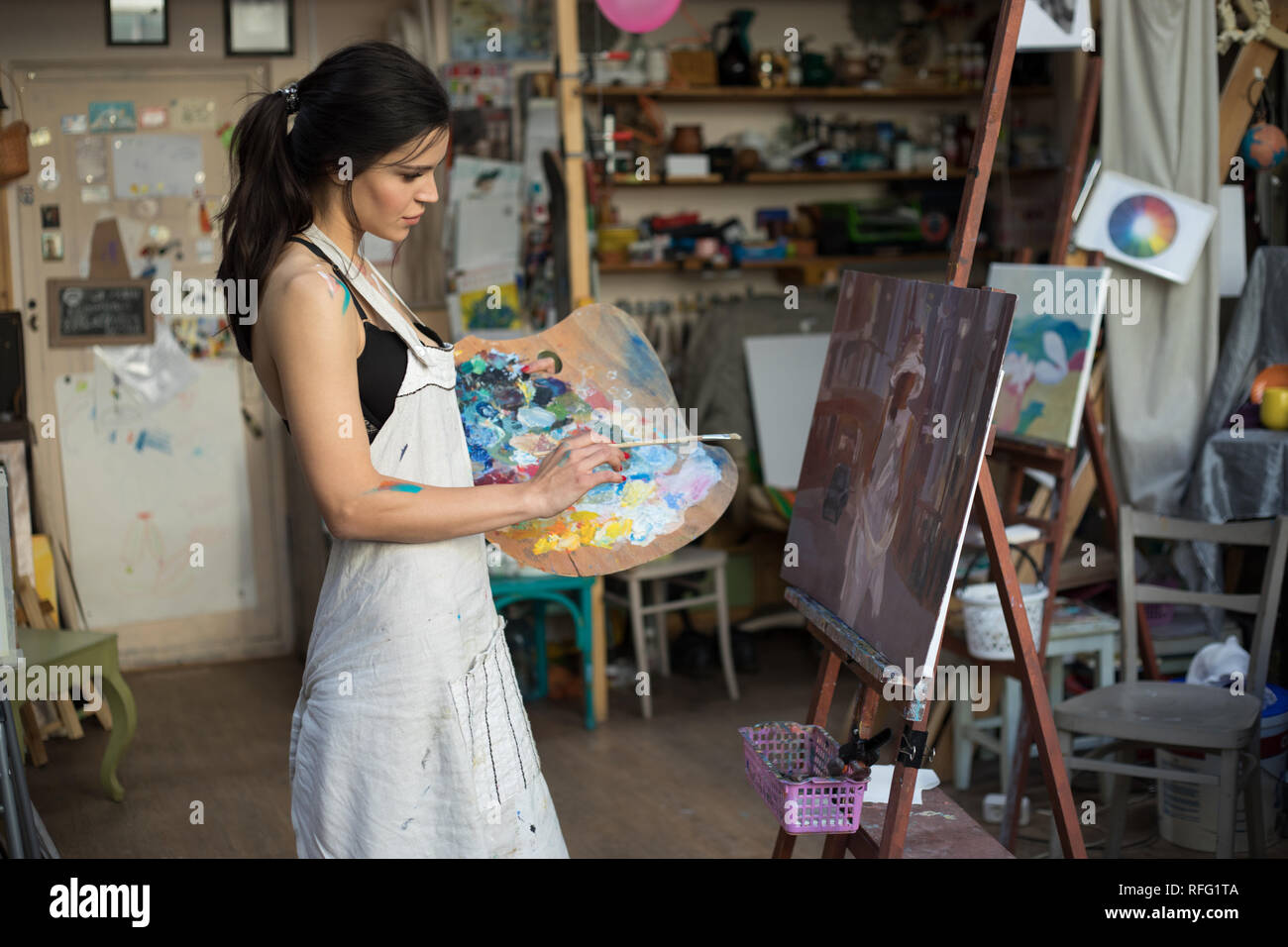Professional Woman artist painting picture in art studio Stock Photo ...