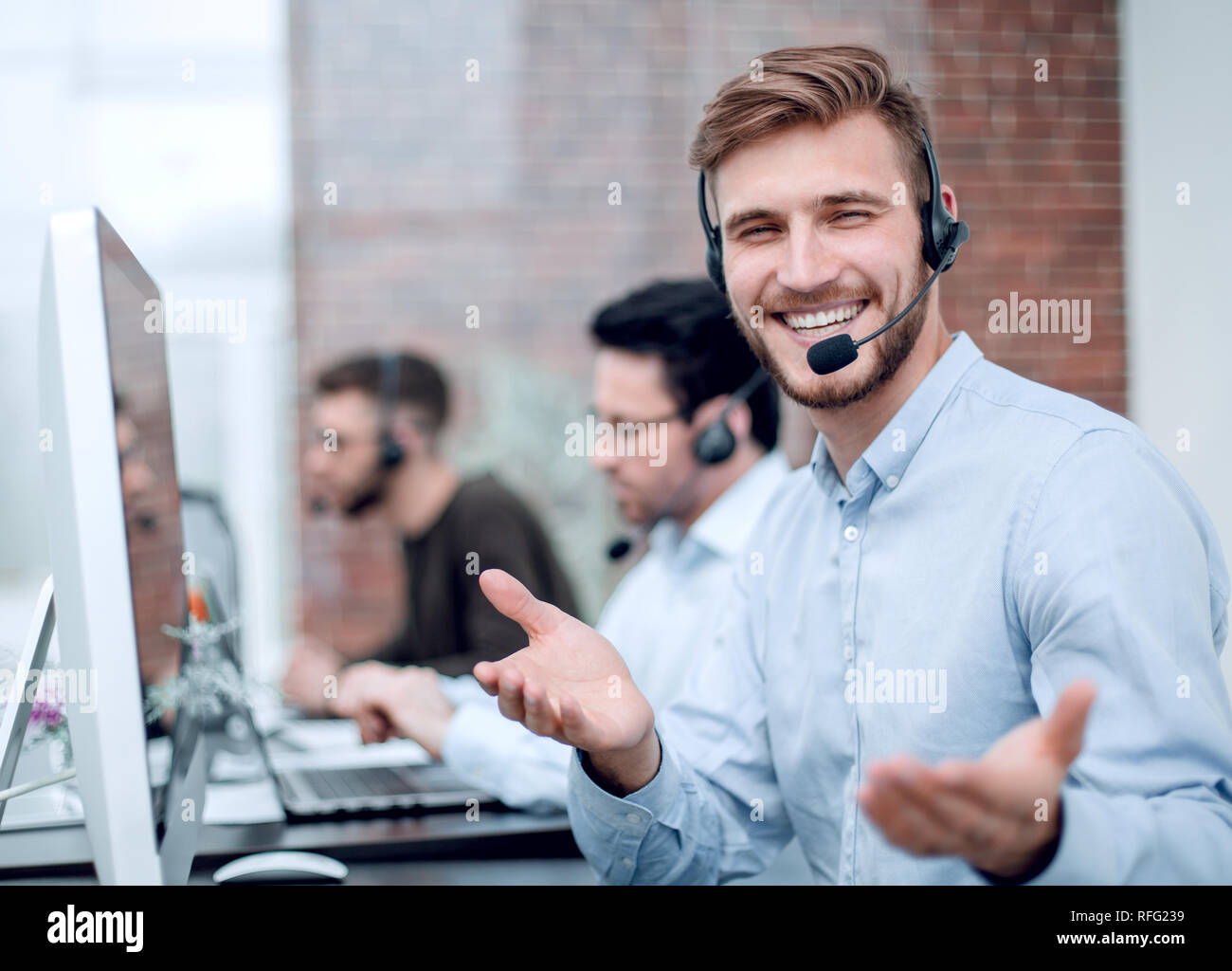 friendly staff with a headset in the workplace in the business center ...