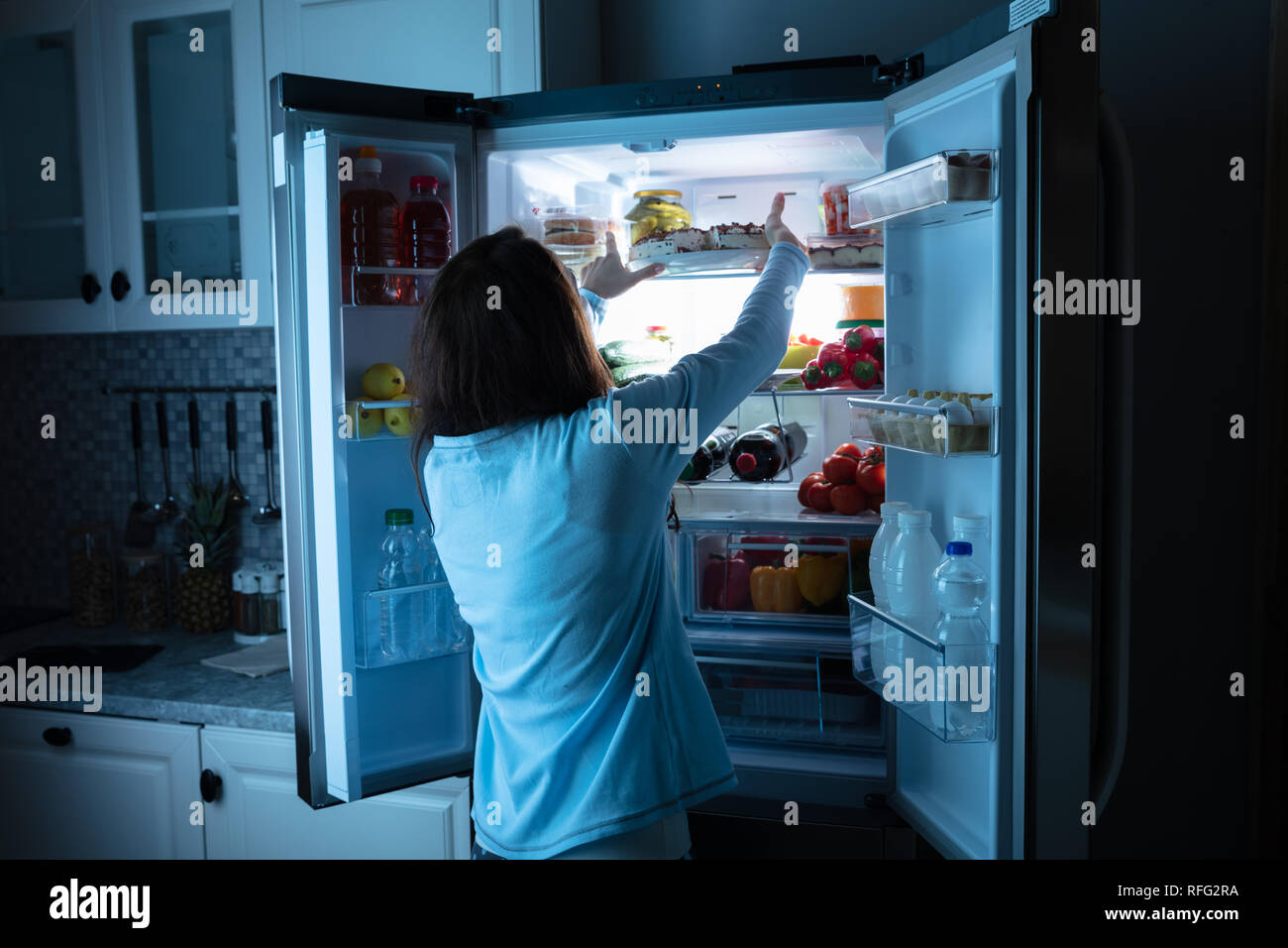 Rear View Of Woman Keeping Food In Refrigerator Stock Photo - Alamy