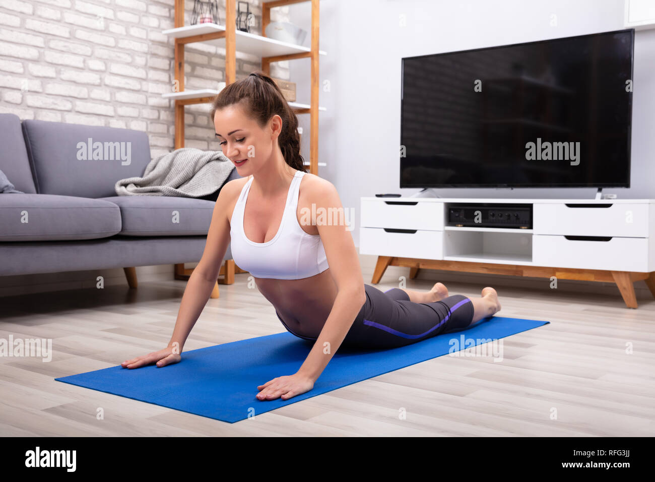 Beautiful Young Woman Lying On Exercise Mat Doing Workout At Home Stock ...