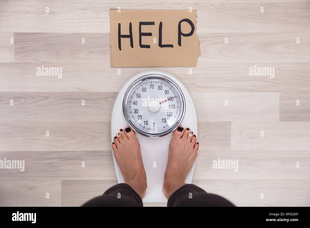 Elevated View Of Help Sign On Cardboard With Woman's Feet On Weighing ...