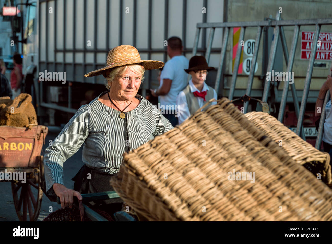 Lady pushing cart of baskets in Old School Parade of traditional trades ...